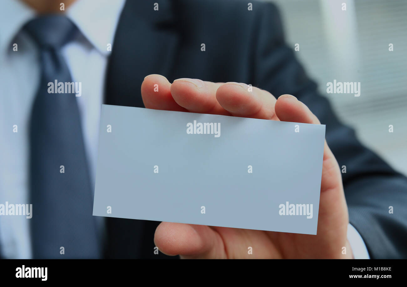Man's hand showing business card - closeup shot on grey background ...