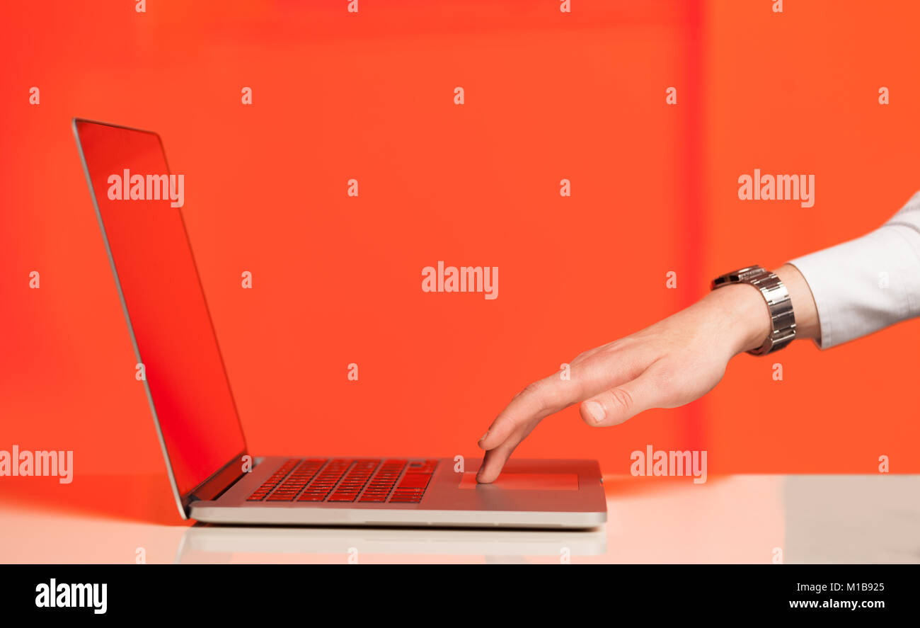 Businessman pressing modern laptop computer on colorful office ...