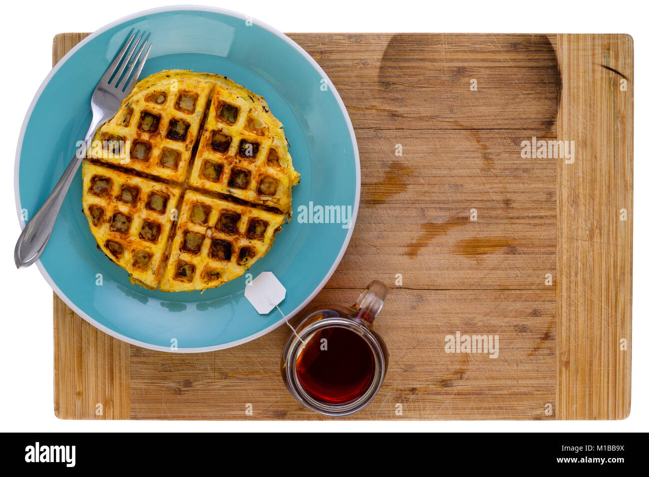 Golden crispy fried hash brown with honey comb waffle pattern on a blue ...