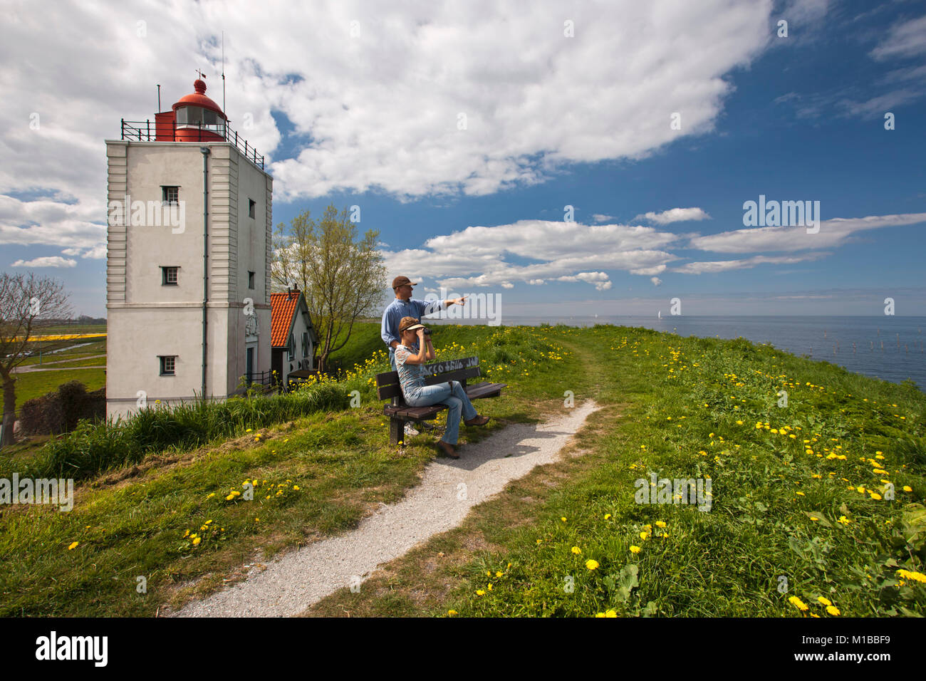 The Netherlands, Oosterdijk, Couple, man and woman on bench near former ...