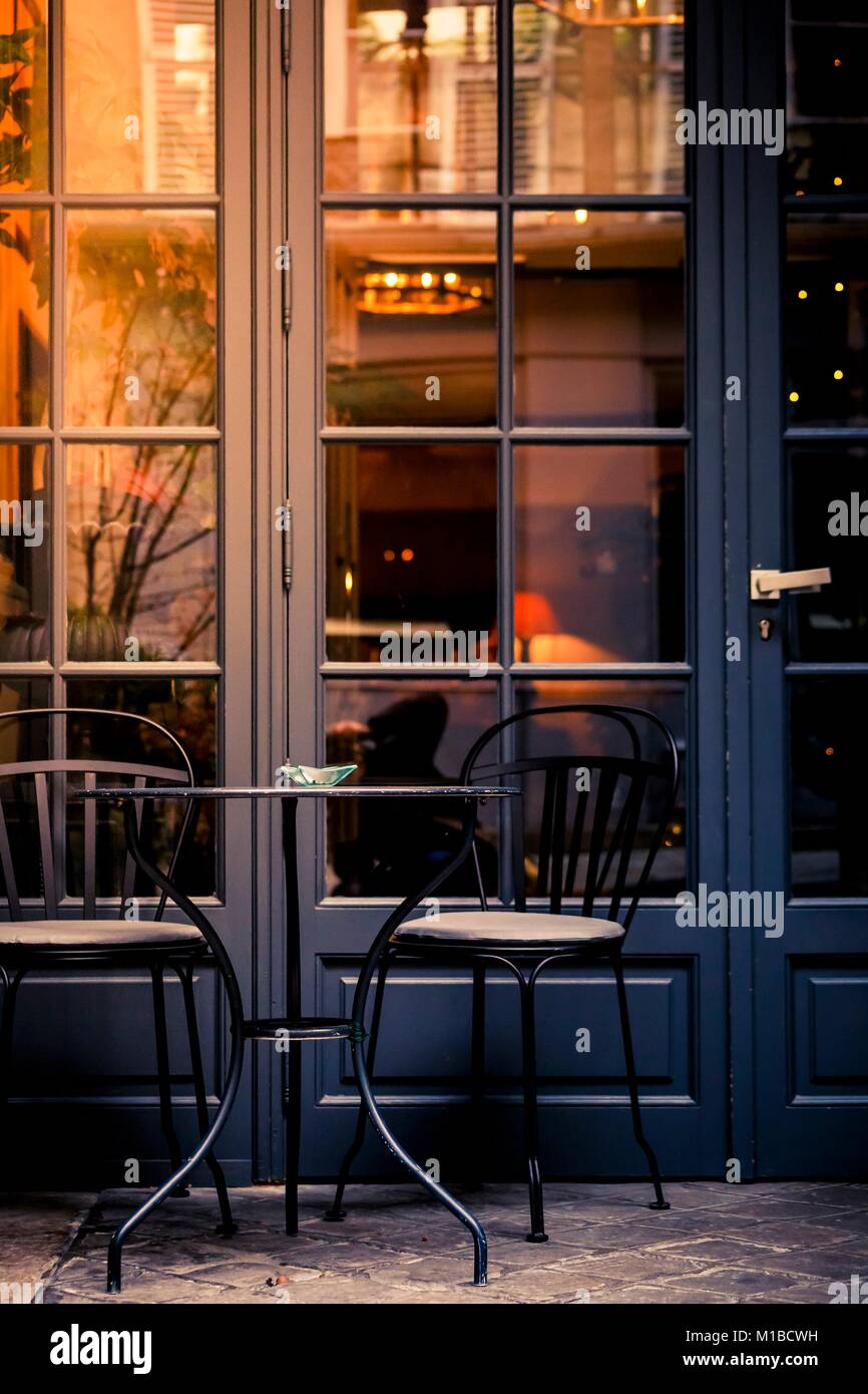 Small wrought iron table and chair on a street outside a cafeteria ...