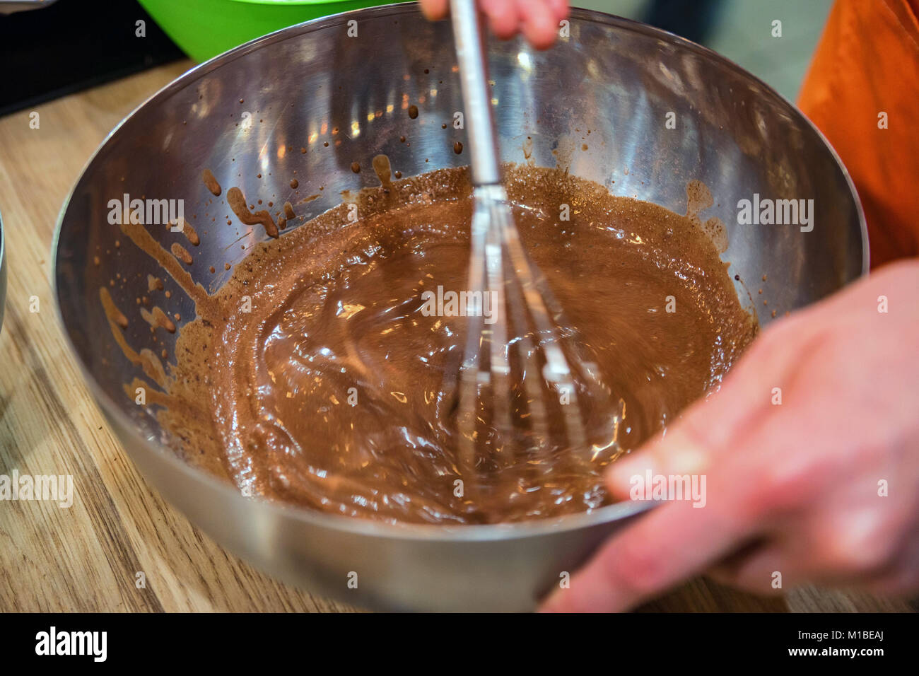 Close up chef's hands mixing ingredients for chocolate pastry iwith ...