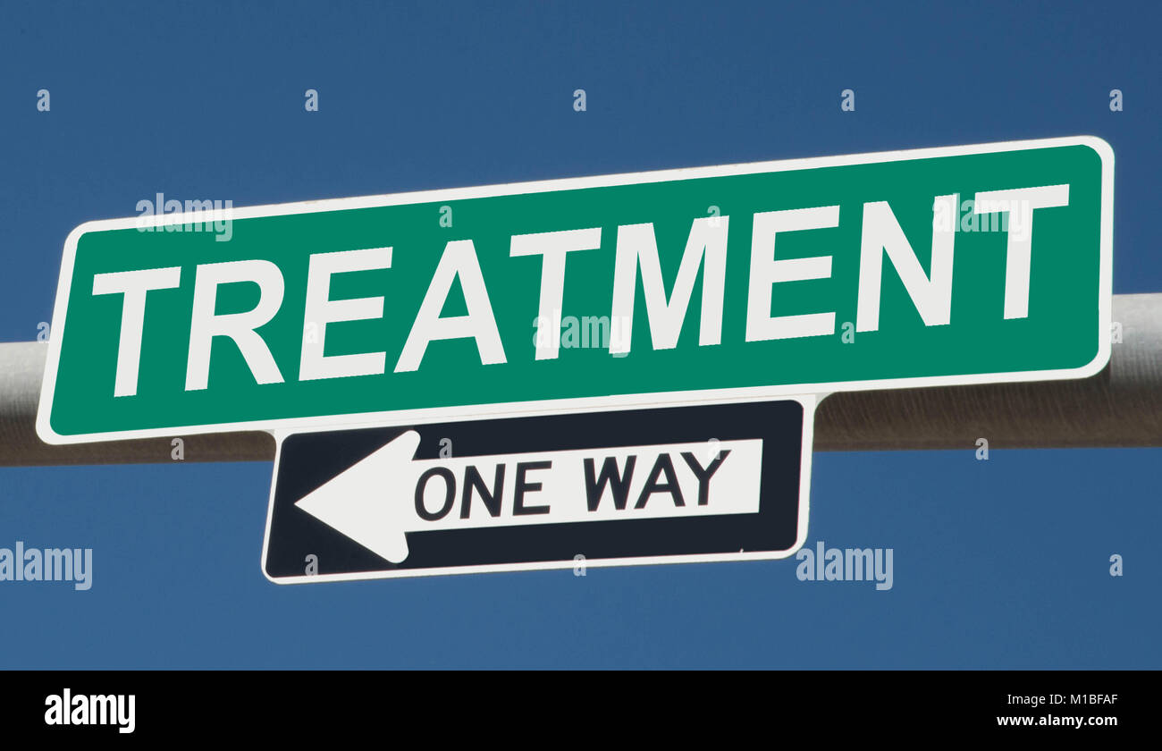 Treatment One Way green highway sign Stock Photo - Alamy