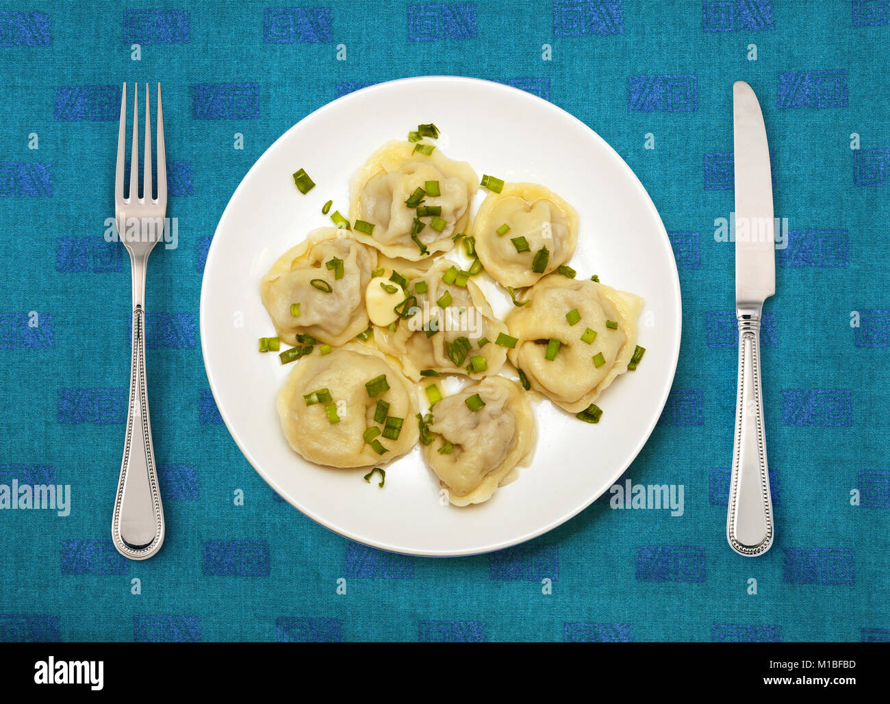 Meat dumplings on white plate and silverware Stock Photo - Alamy