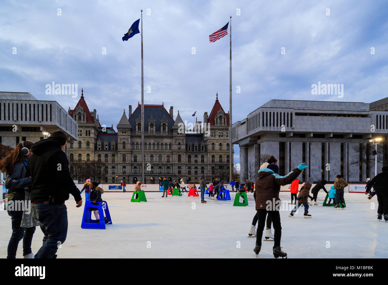 Families enjoying the winter weather and ice skating on Empire Plaza ...