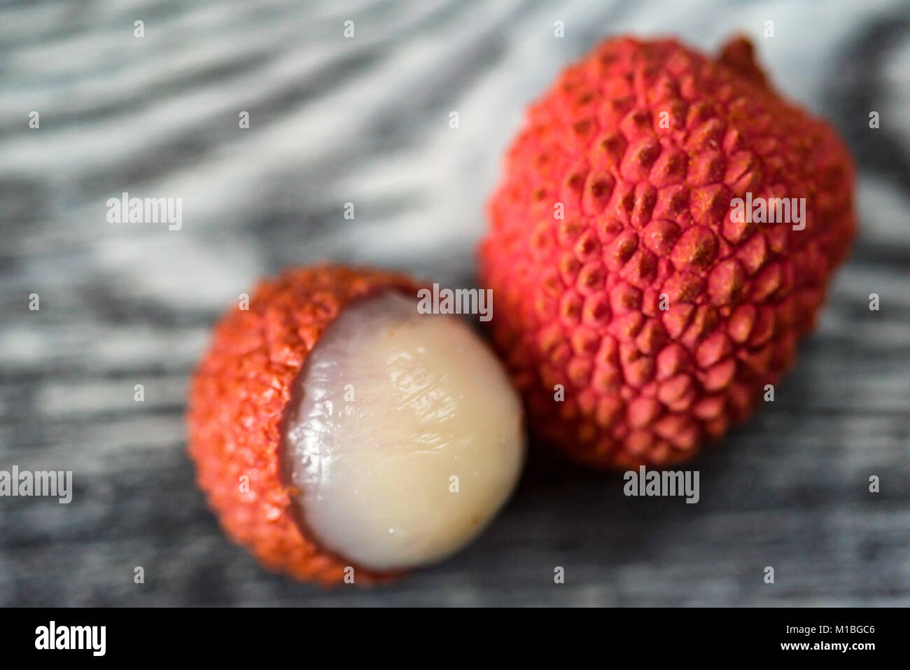 Two lychee fruits wooden background Stock Photo - Alamy