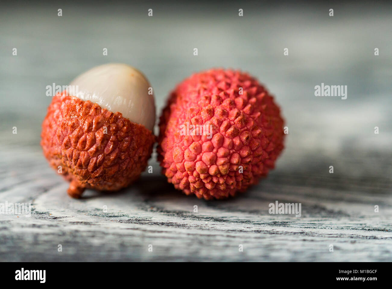 Two lychee fruits wooden background Stock Photo - Alamy
