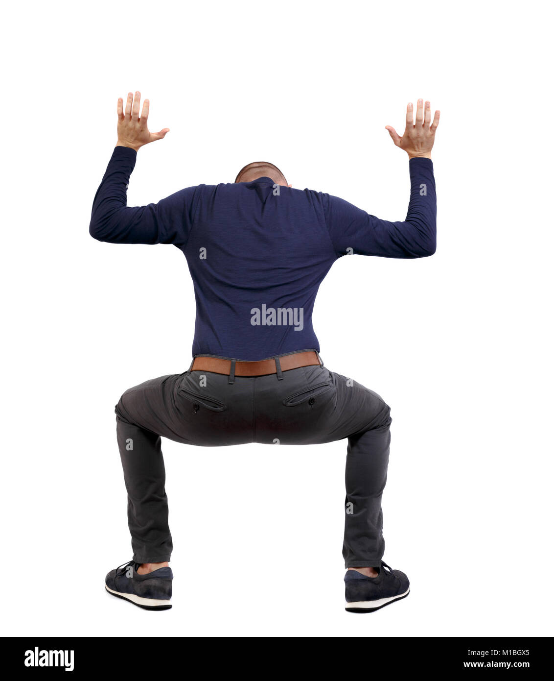 back view. man protects hands from what is falling from above. Man ...