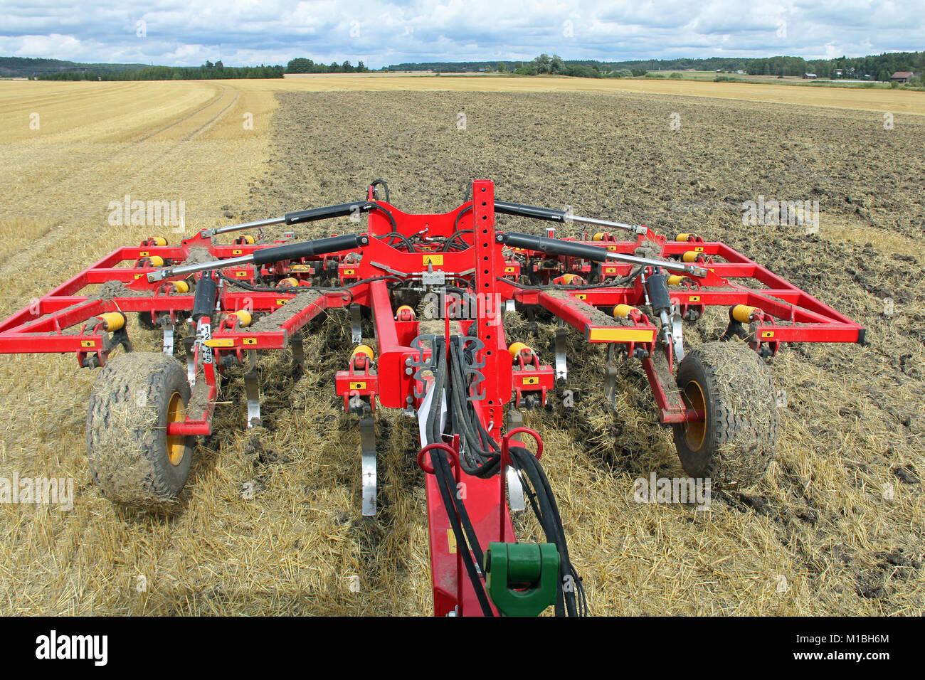 Tilling a stubble field with cultivator as seen from the tractor Stock ...