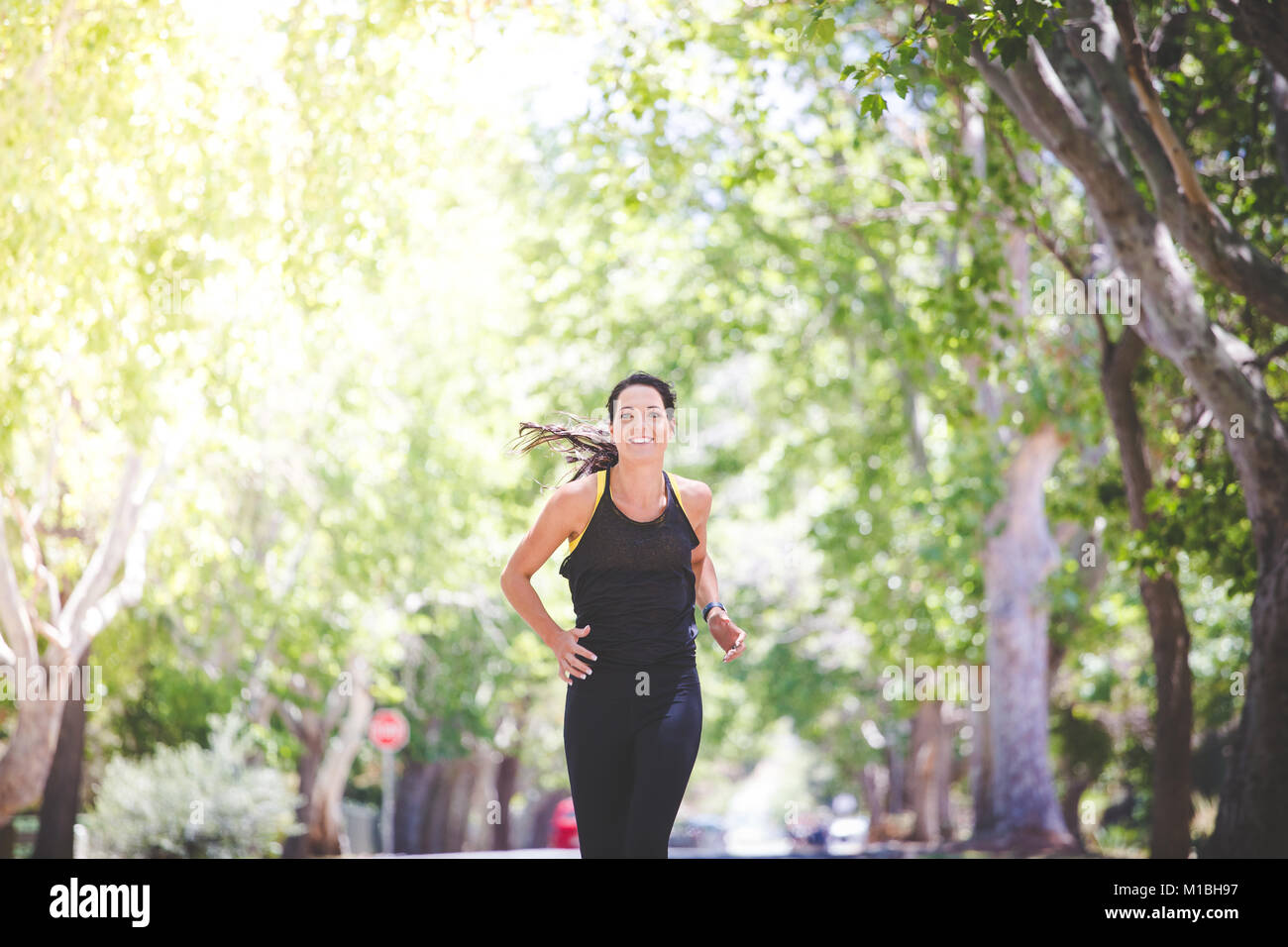 Beautiful brunette female fitness model running / stretching ...