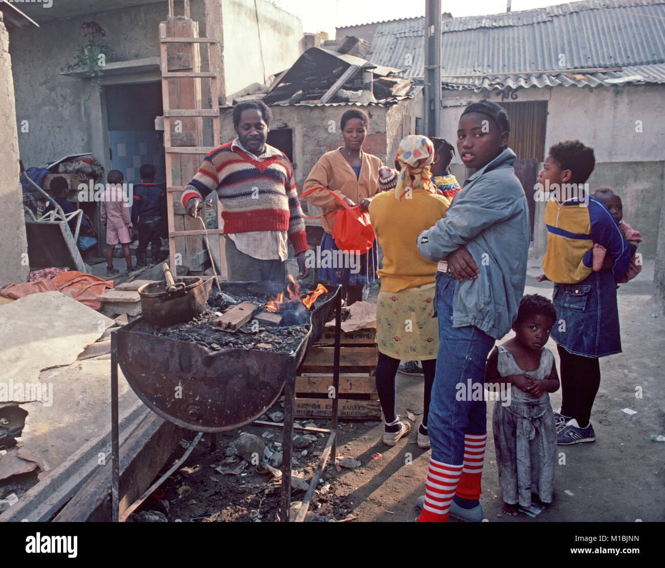 Cape Verde residents standing around charcoal fire in Lisbon, Portugal ...