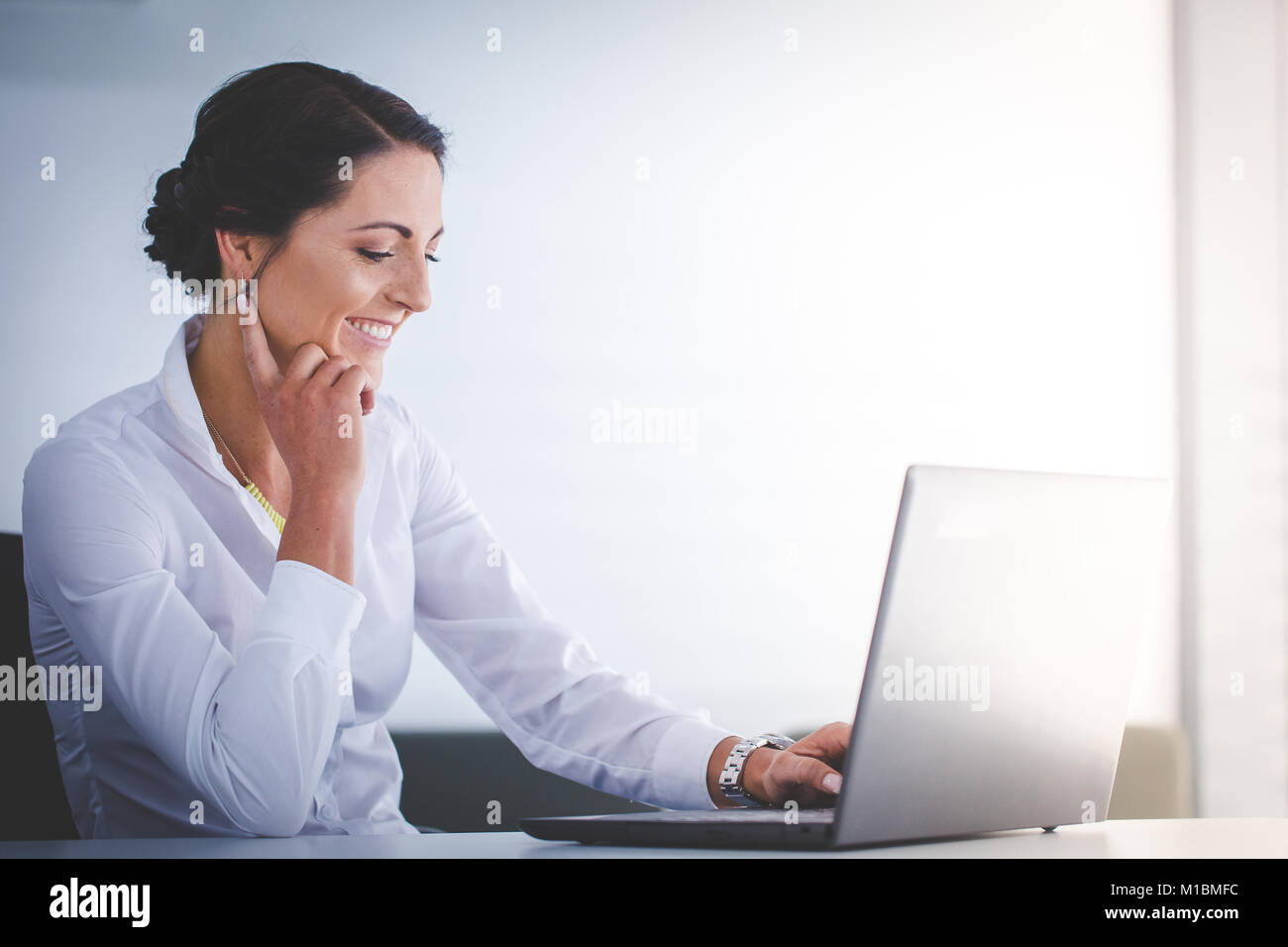 Beautiful brunette female business woman working on her laptop in her ...