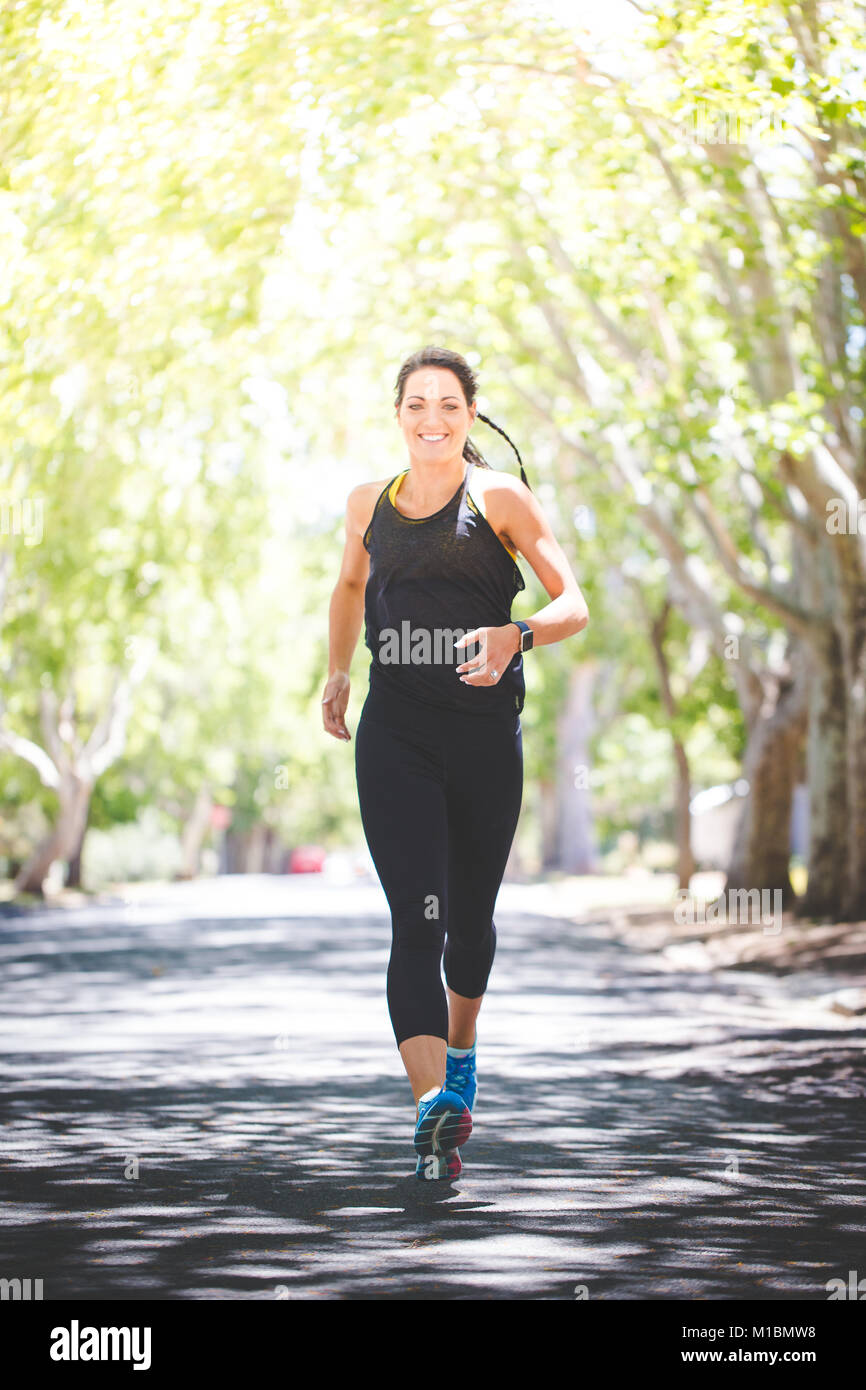 Beautiful brunette female fitness model running / stretching ...