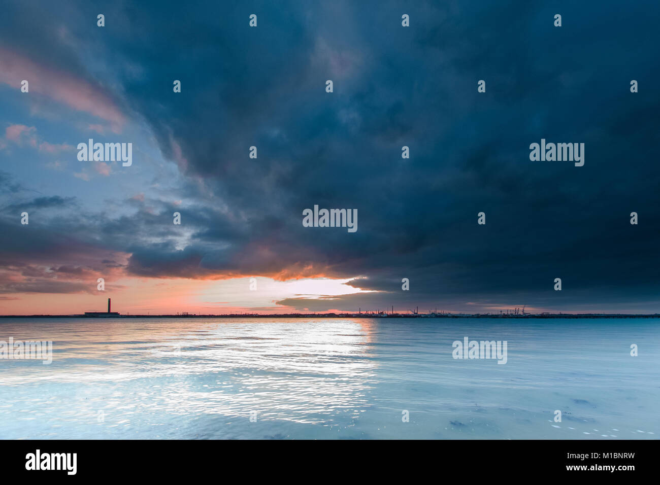 Fawley Refinery at sunset with dramatic sky and slow shutter speeds ...