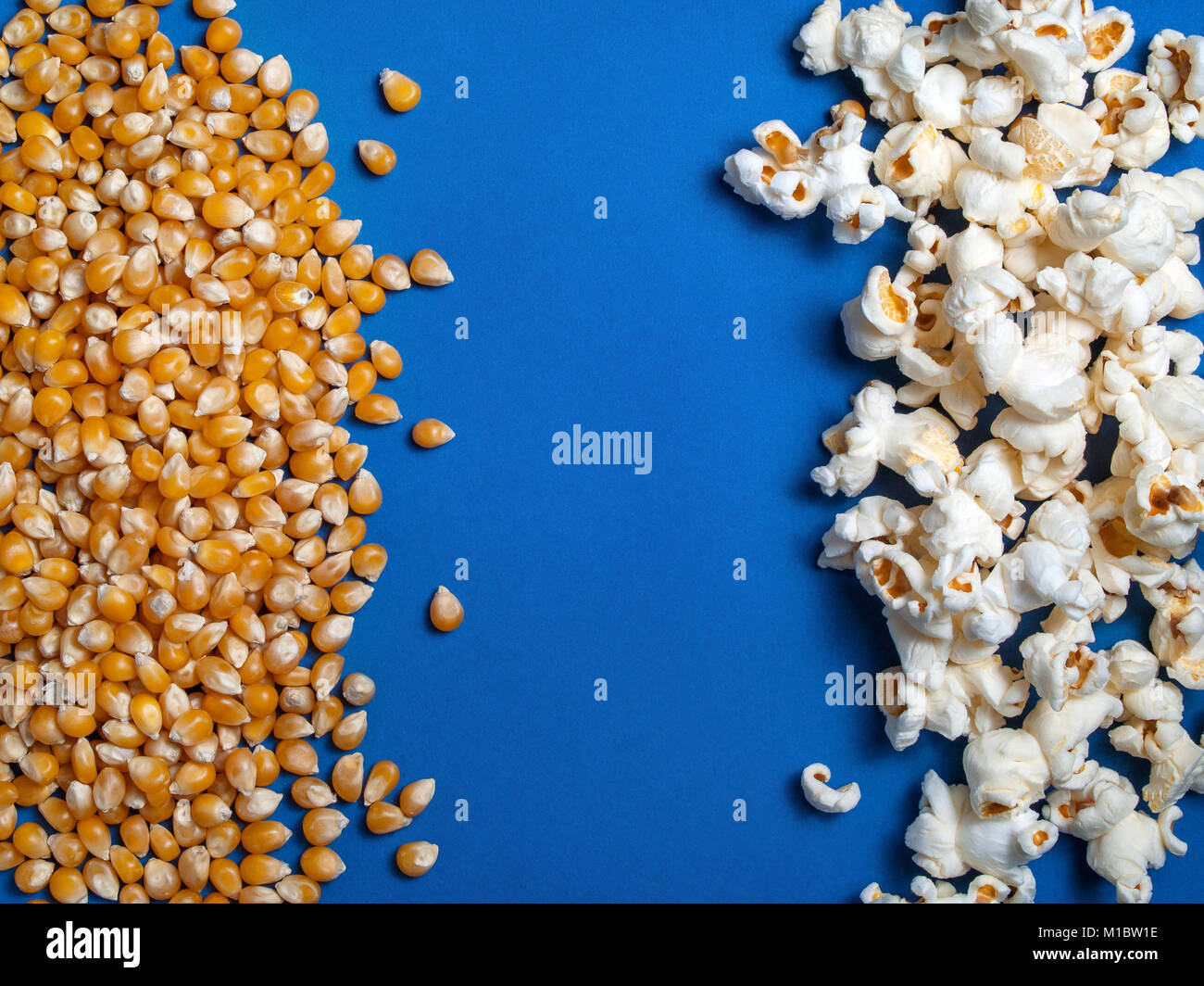 Ready popcorn and corn kernels on a blue background close-up with a top ...