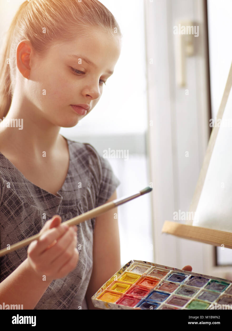 Artist painting on easel in studio. Girl paints with brush Stock Photo ...