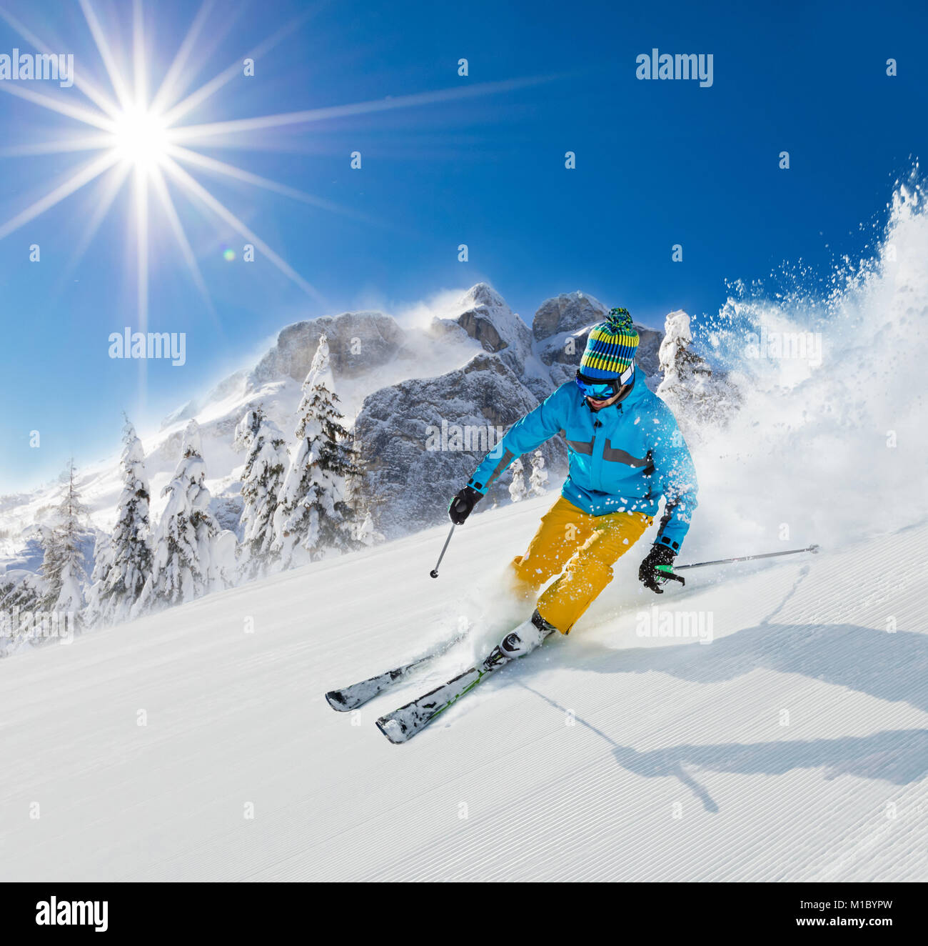 Young man skiing downhill in Alps. Beautiful clear blue sky. Winter ...
