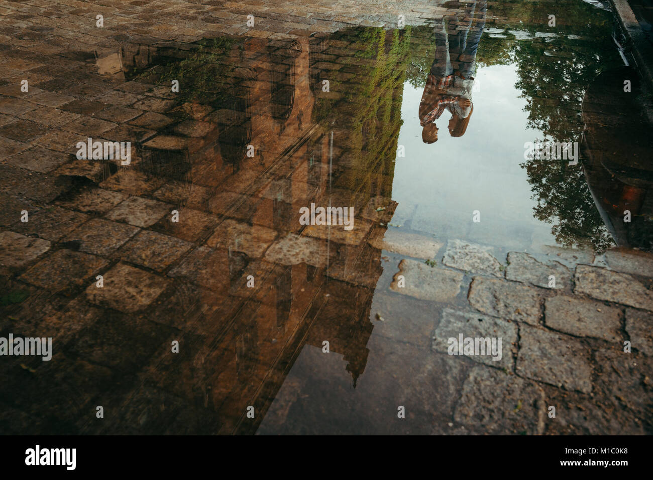 The reflection of the charming hugging couple in the puddle. Poland ...