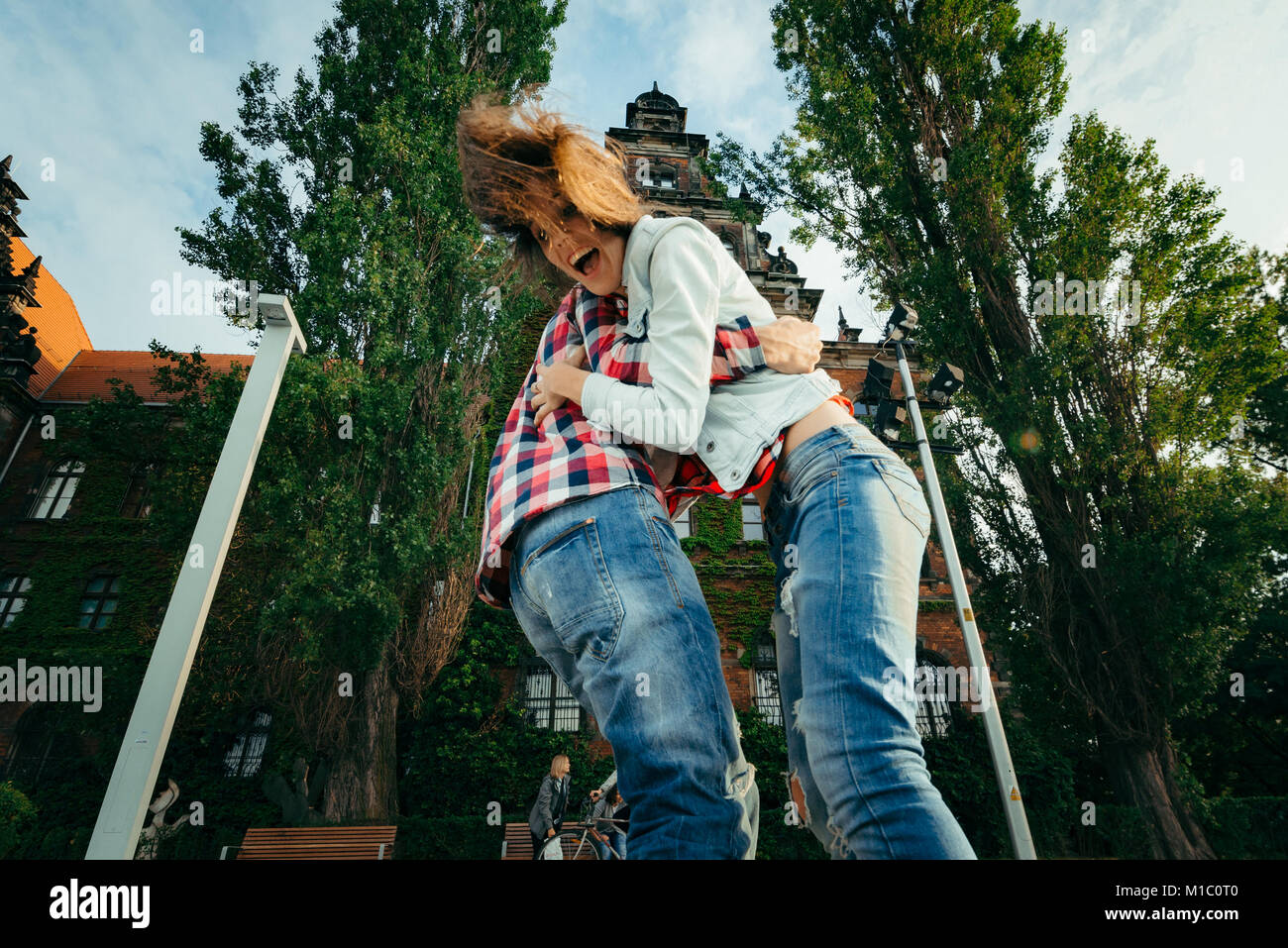 Cheerful pretty hugging and jumping couple. Up view of the emotional ...