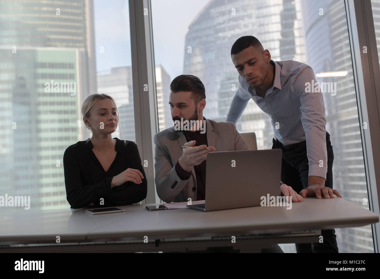 The business people sit at the table and work in the office Stock Photo ...