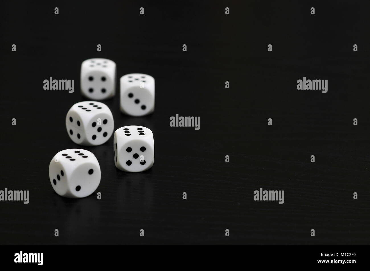 Five white dice on black table Stock Photo - Alamy