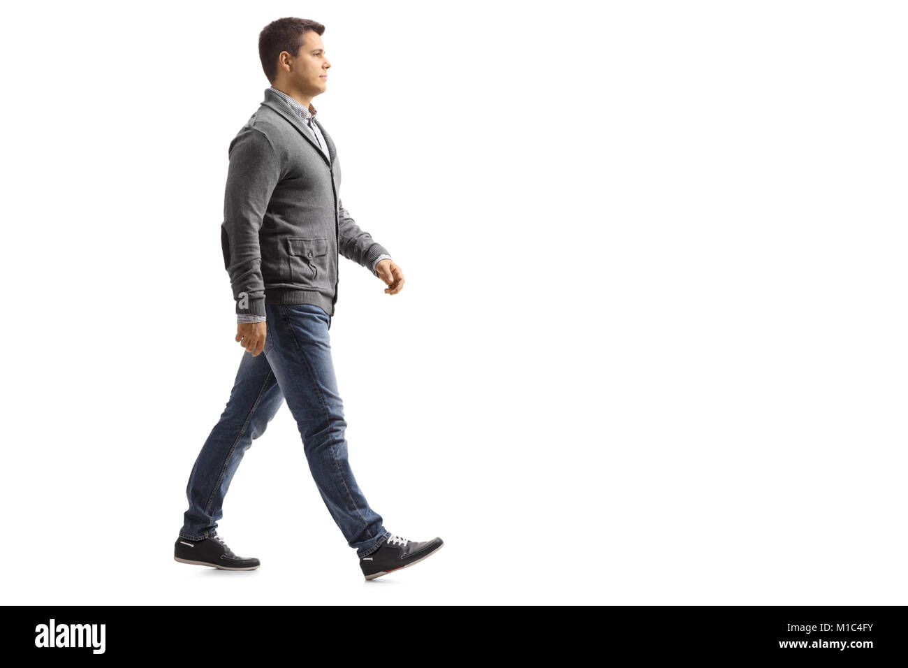 Full length profile shot of a young man walking isolated on white ...
