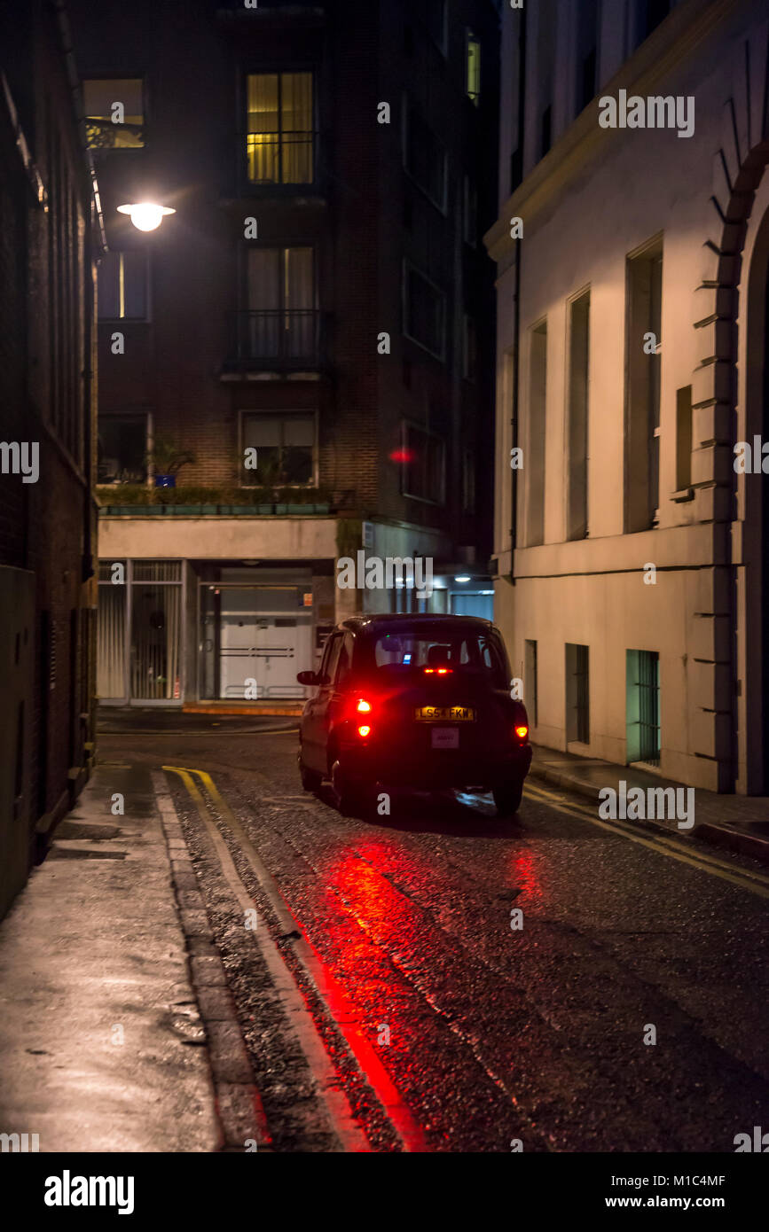 Black cab in a street in Mayfair at night, City of Westminster, London ...