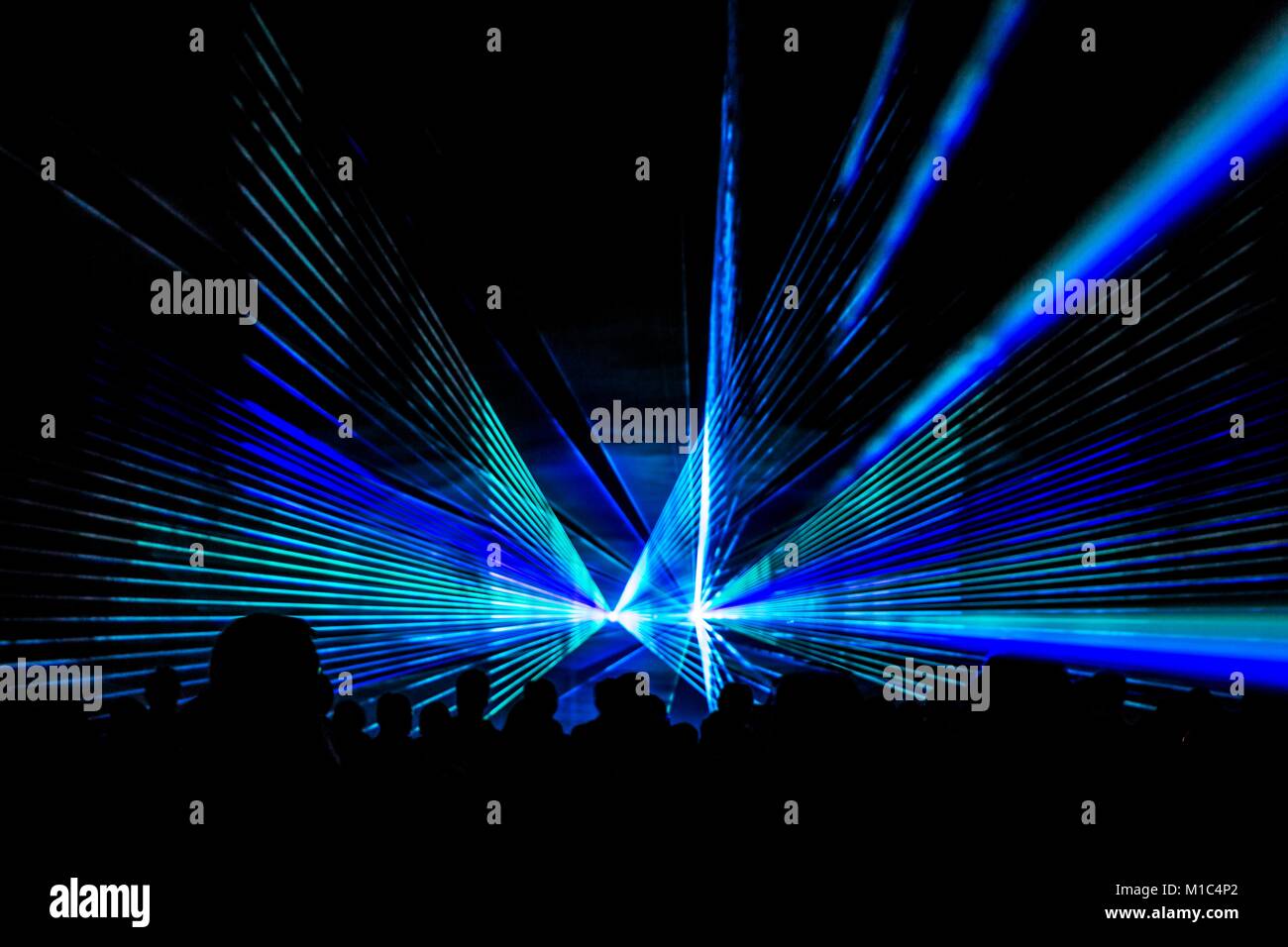 Blue laser show nightlife club stage with party people crowd. Luxury ...