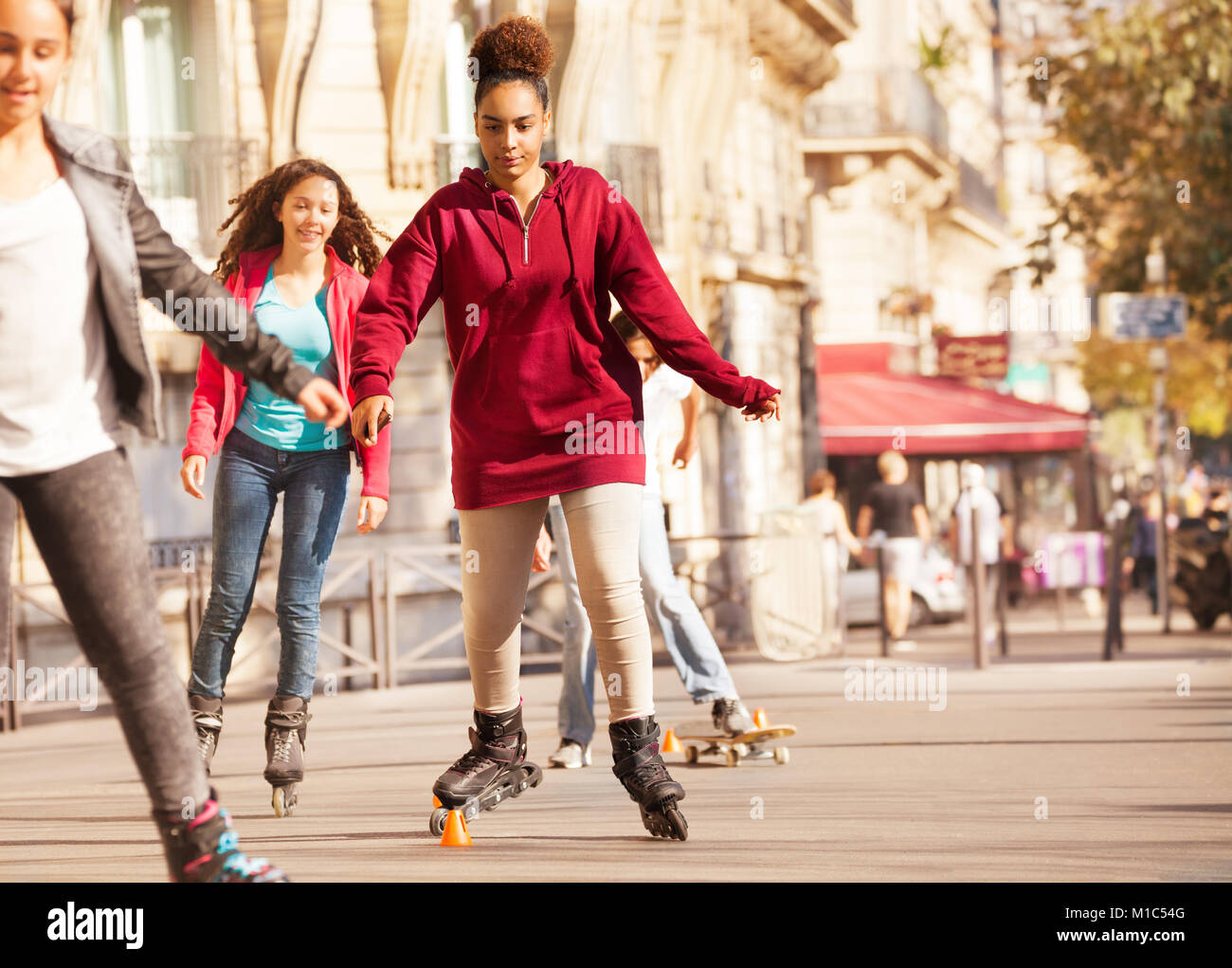 Portrait of African teenage girl roller skating around the cones at ...