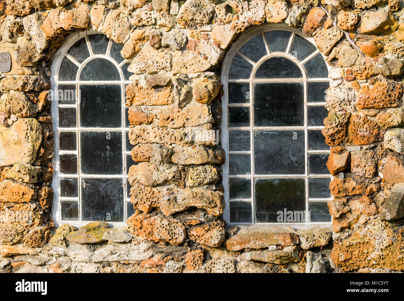Close up of arched windows of quirky rustic rubble built curling lodge ...