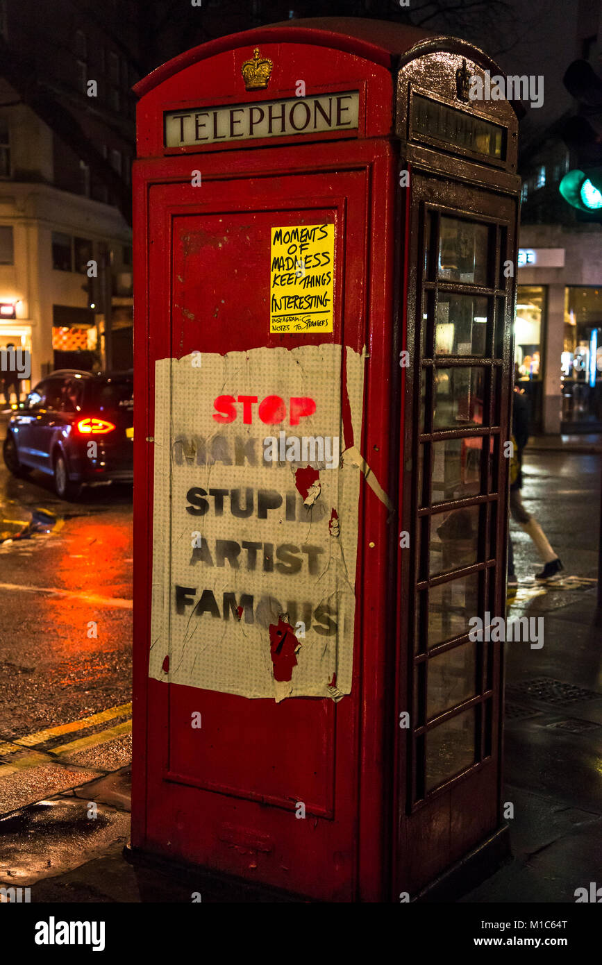 Telephone box with graffiti 'Stop making stupid artists famous ...