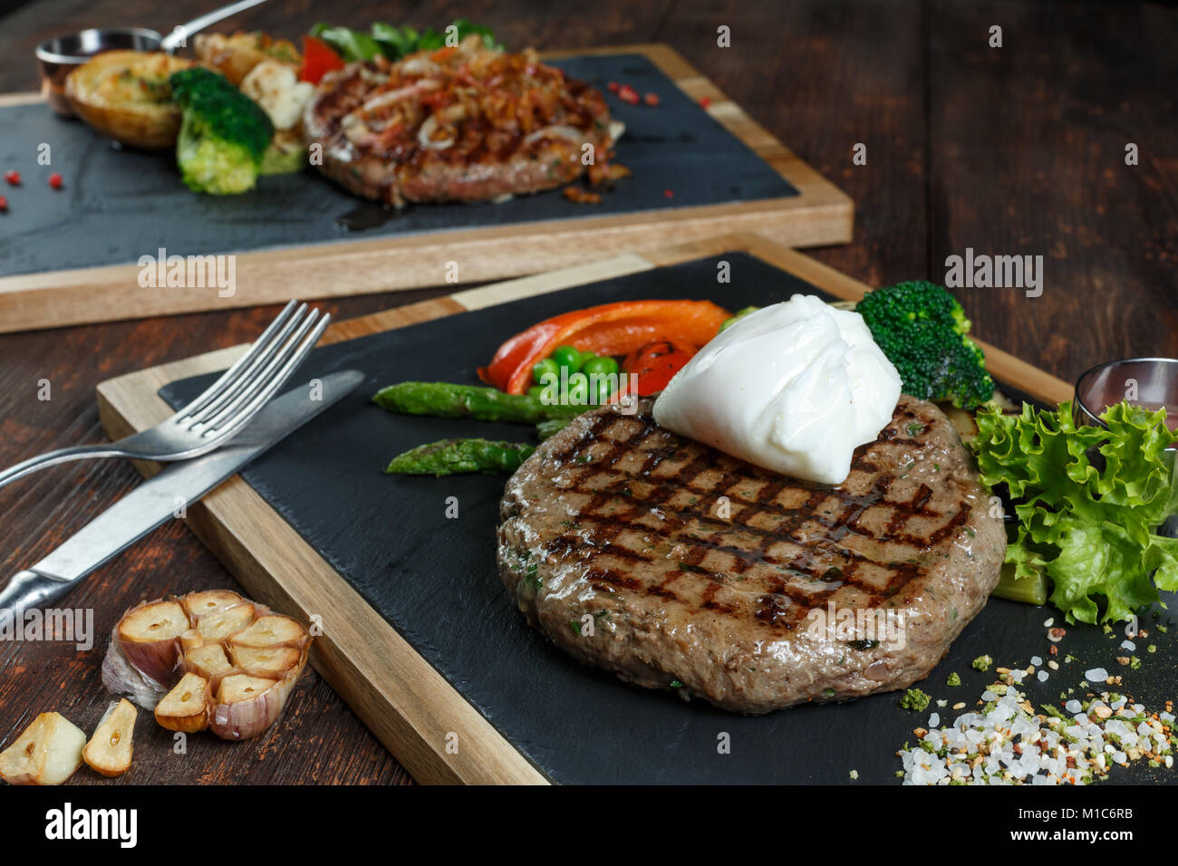 Grilled beef steak cooked on barbecue, closeup on dark wooden table ...