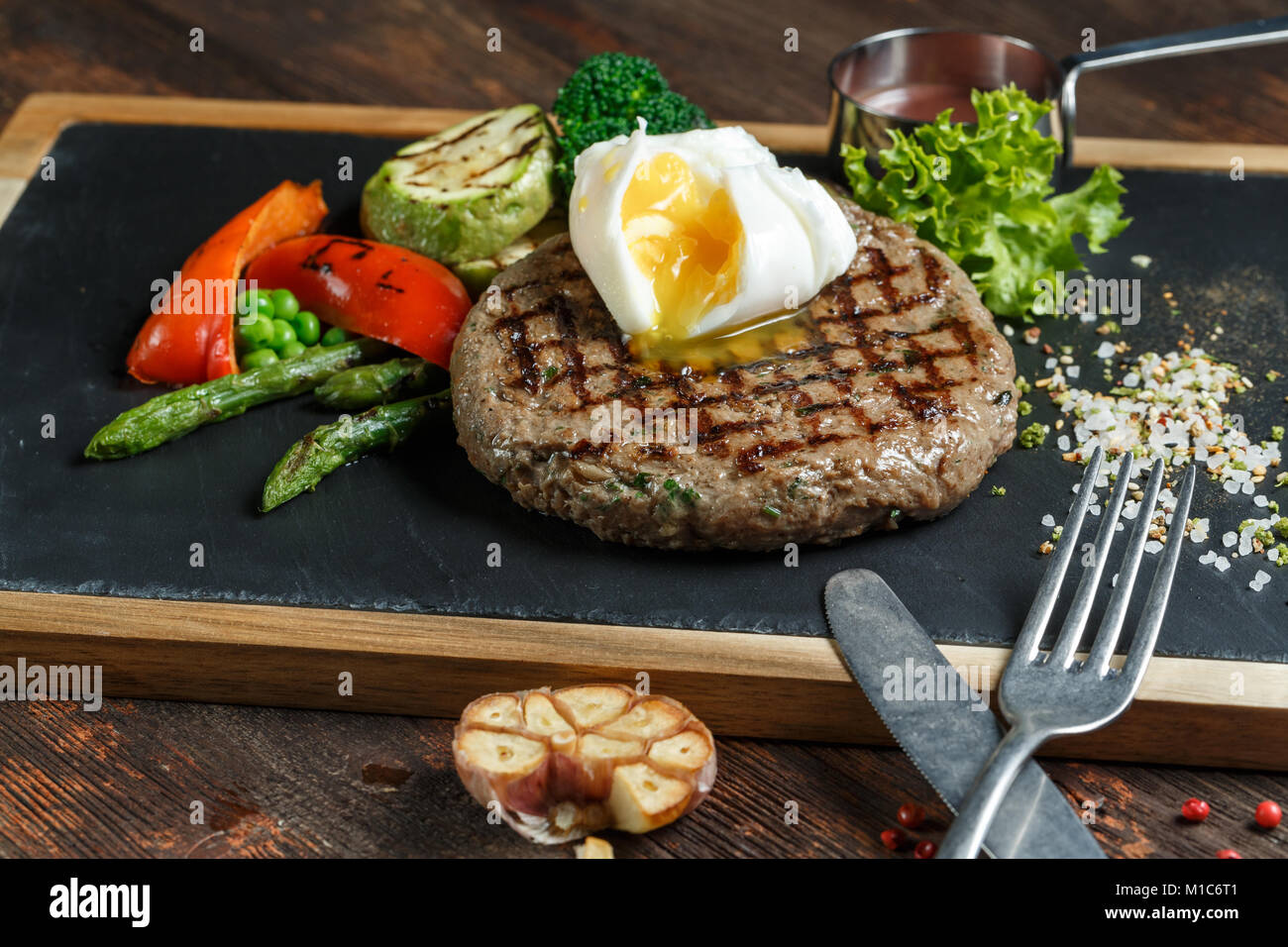 Grilled beef steak cooked on barbecue, closeup on dark wooden table ...