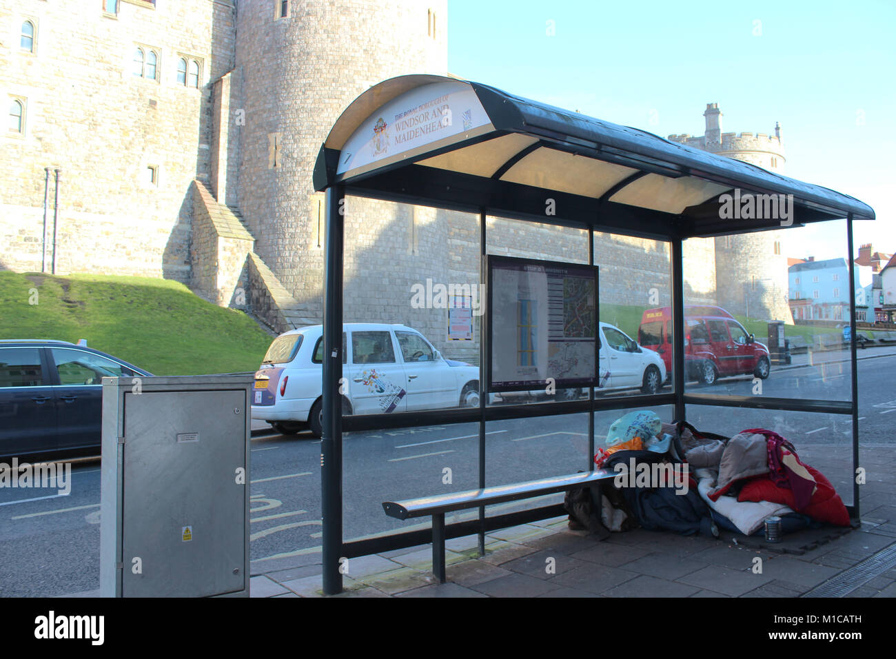 A homeless person has sat down inside a bus stop in order to avoid the ...