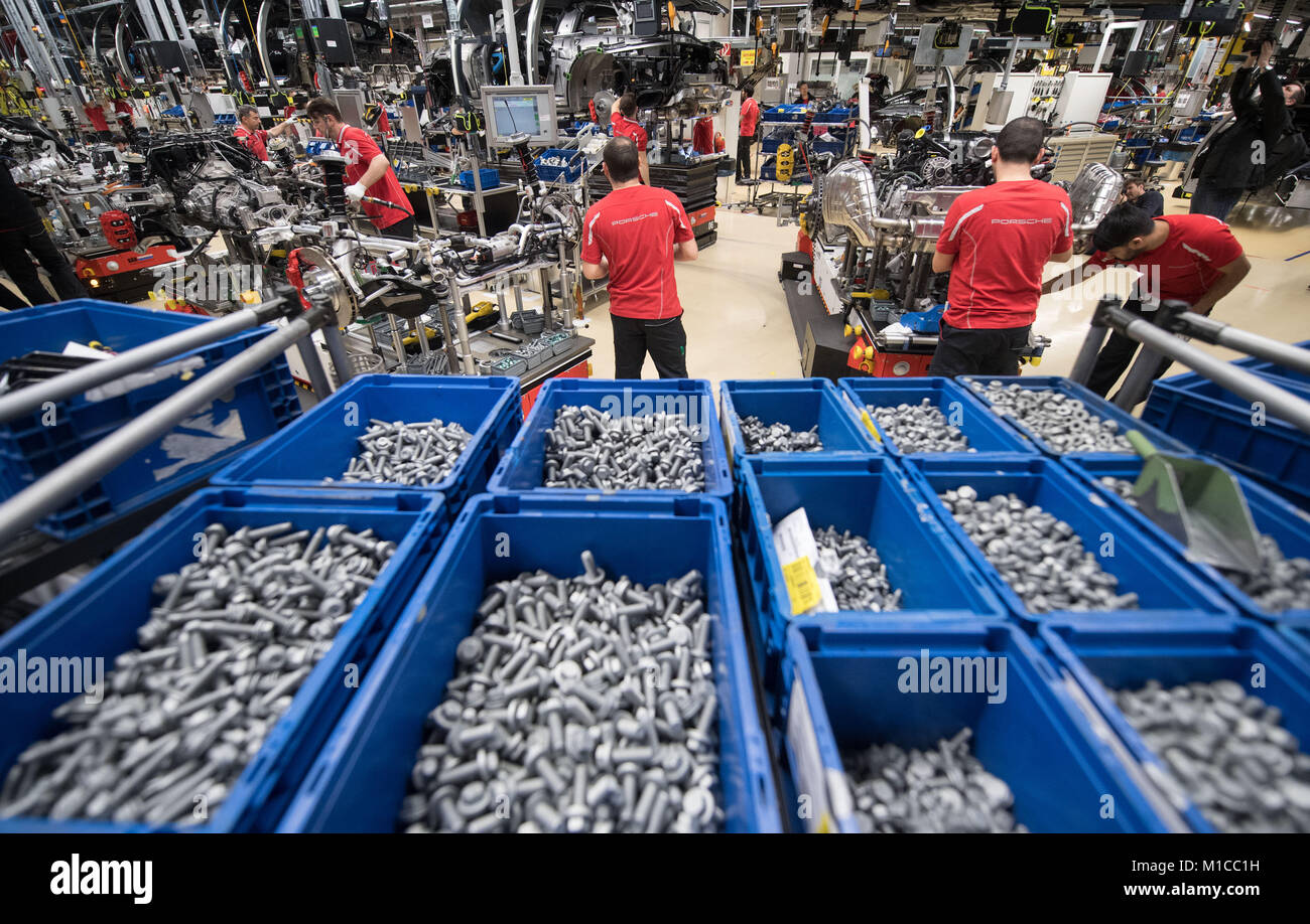 Employees work on car parts at a manufacturing facility of German ...