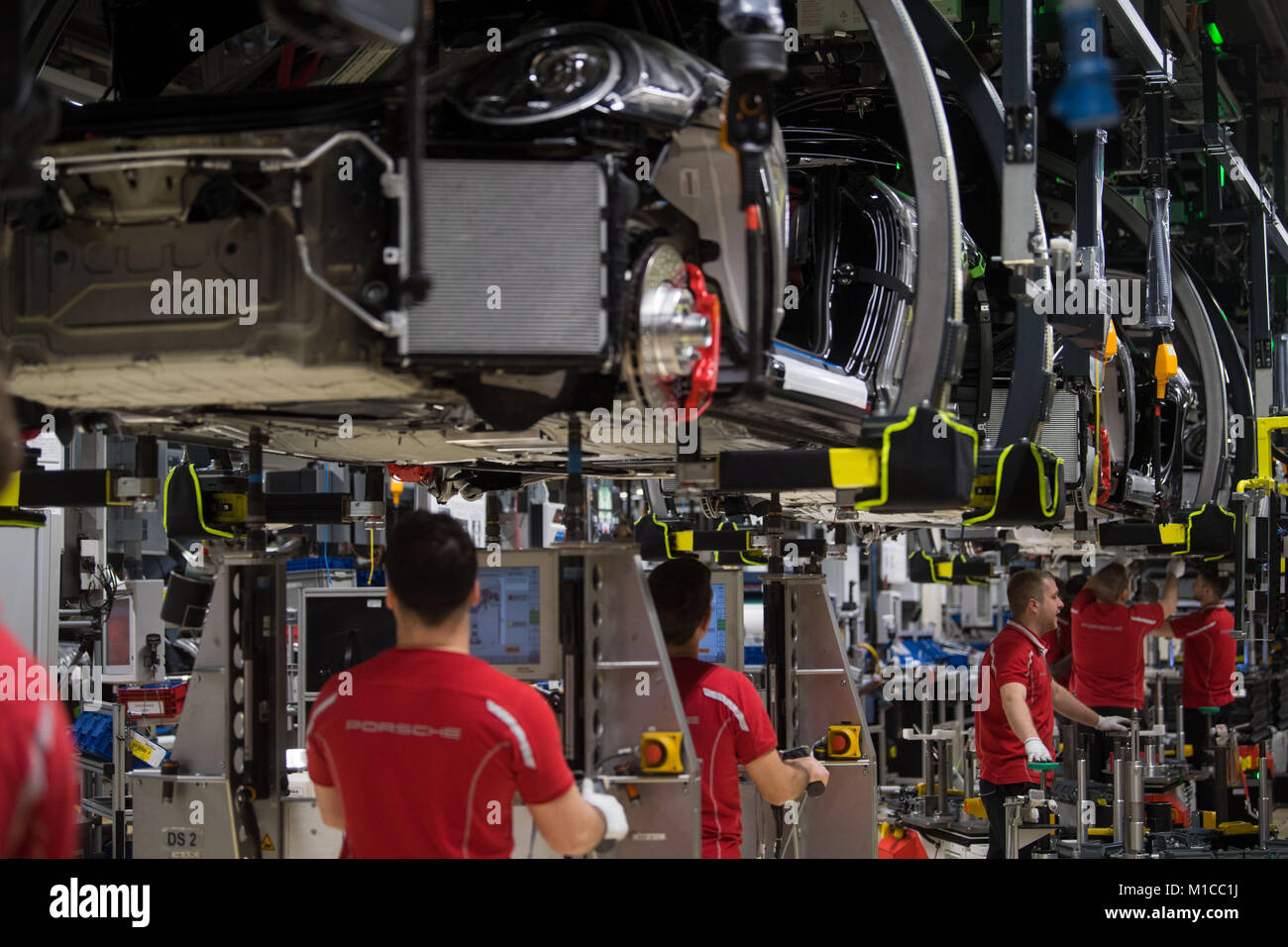 Employees work on car parts at a manufacturing facility of German ...