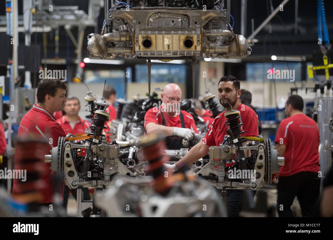 Employees work on car parts at a manufacturing facility of German ...