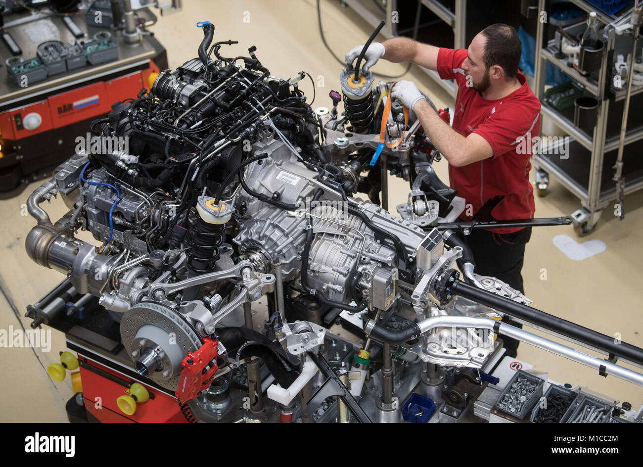 Employees work on cars at a manufacturing facility of German automobile ...
