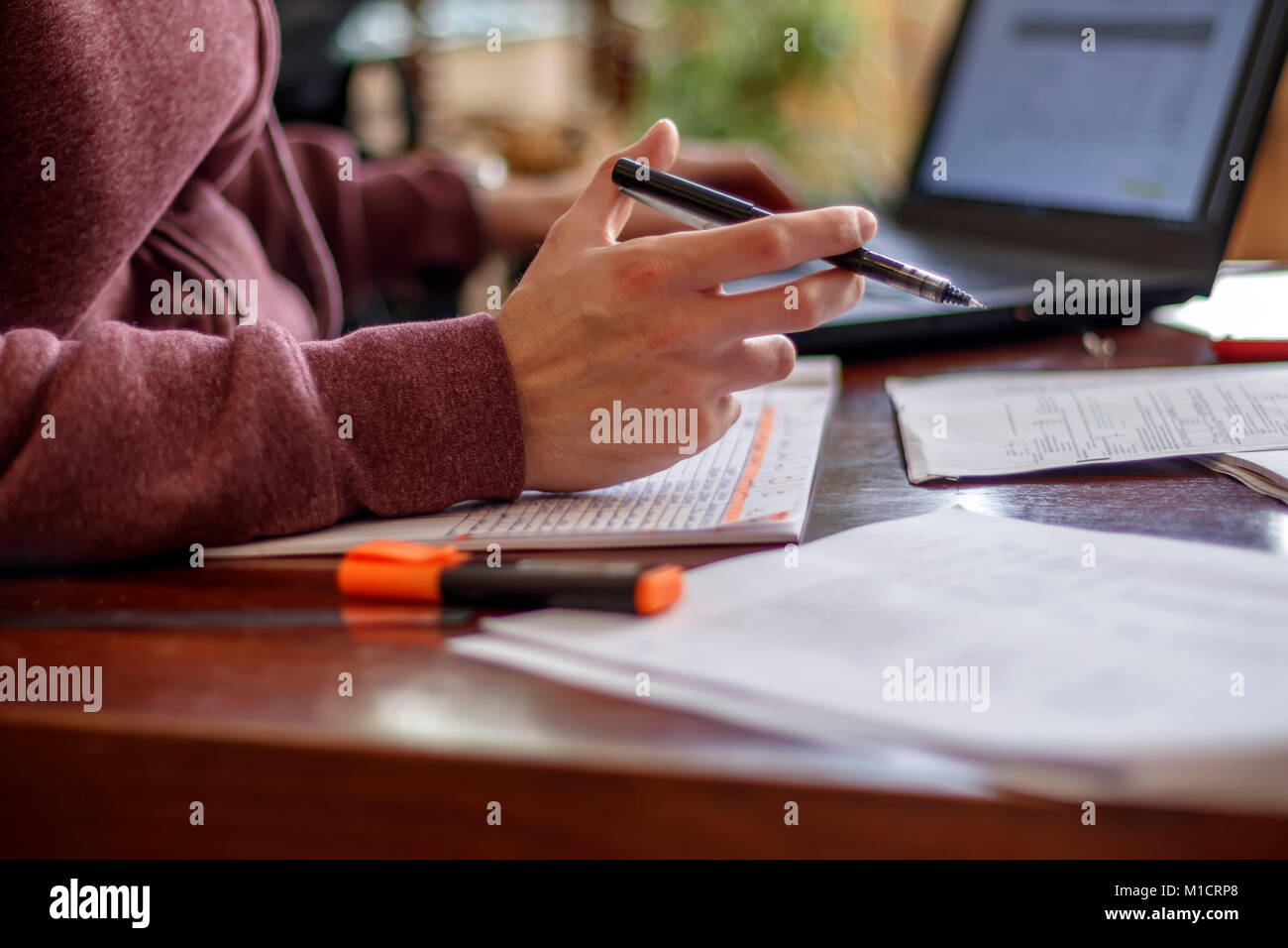 Hand of a young man with a pen over his notebook Stock Photo - Alamy