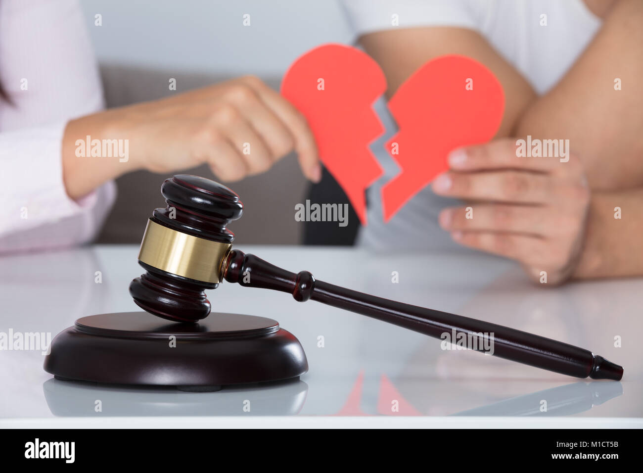Couple Holding Broken Heart Behind Gavel In Courtroom Stock Photo - Alamy