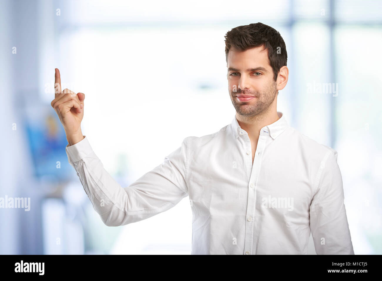Portrait of smiling young businessman pointing something with his ...