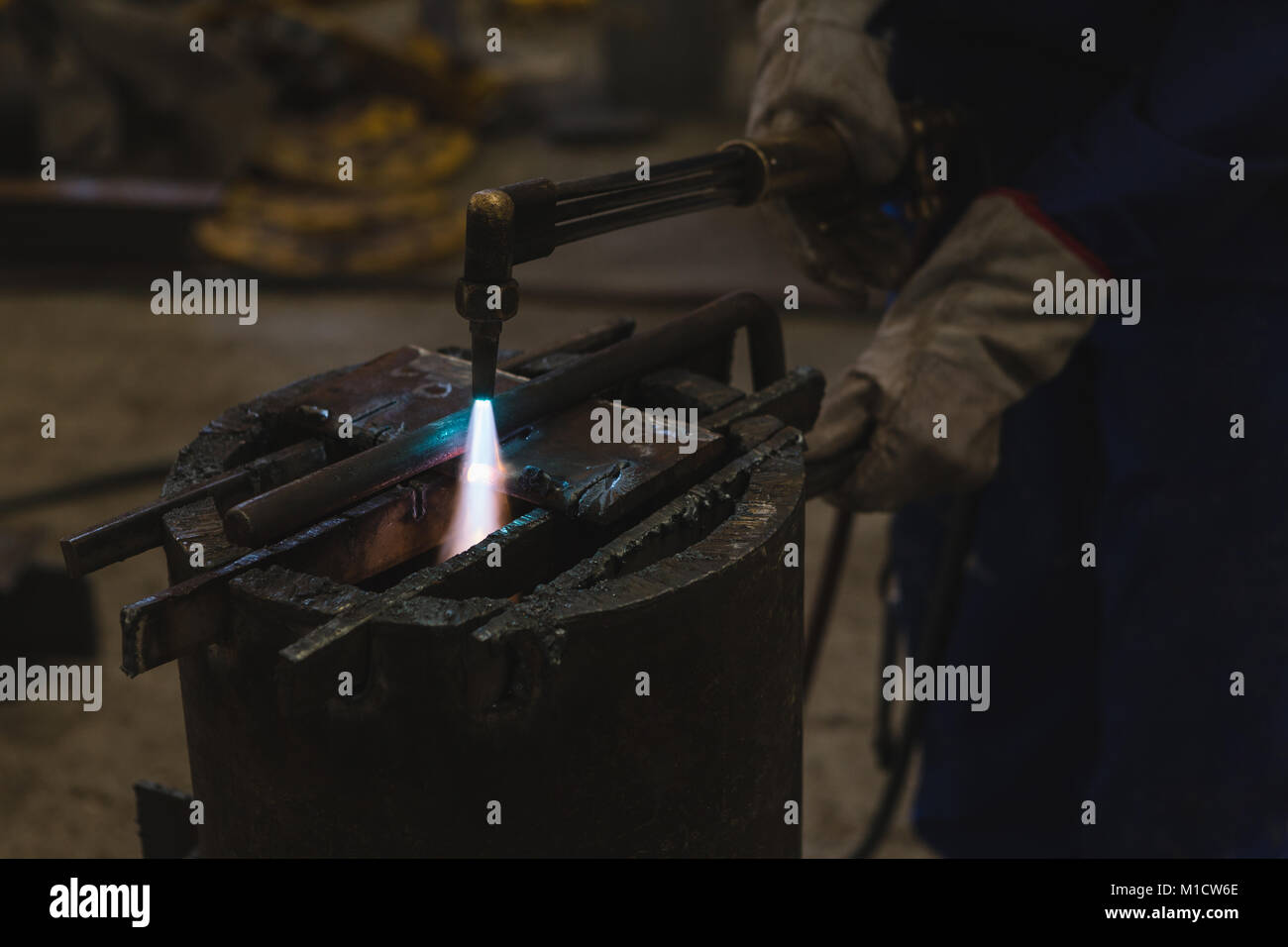 Mid section of welder repairing vessel part Stock Photo - Alamy