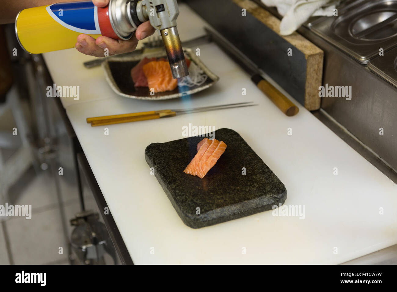 Chef heating seafood with burner Stock Photo - Alamy