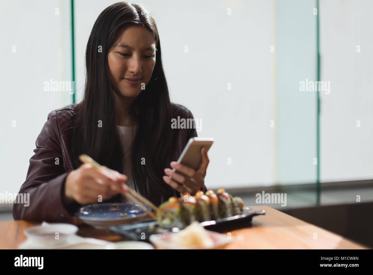 Woman using mobile phone while having meal in restaurant Stock Photo ...