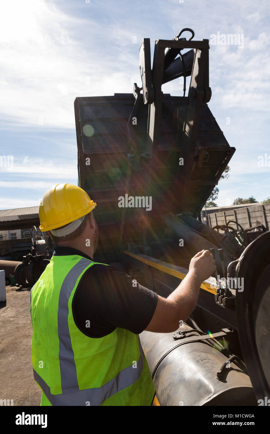 Worker lifting the container of a dumper truck Stock Photo - Alamy