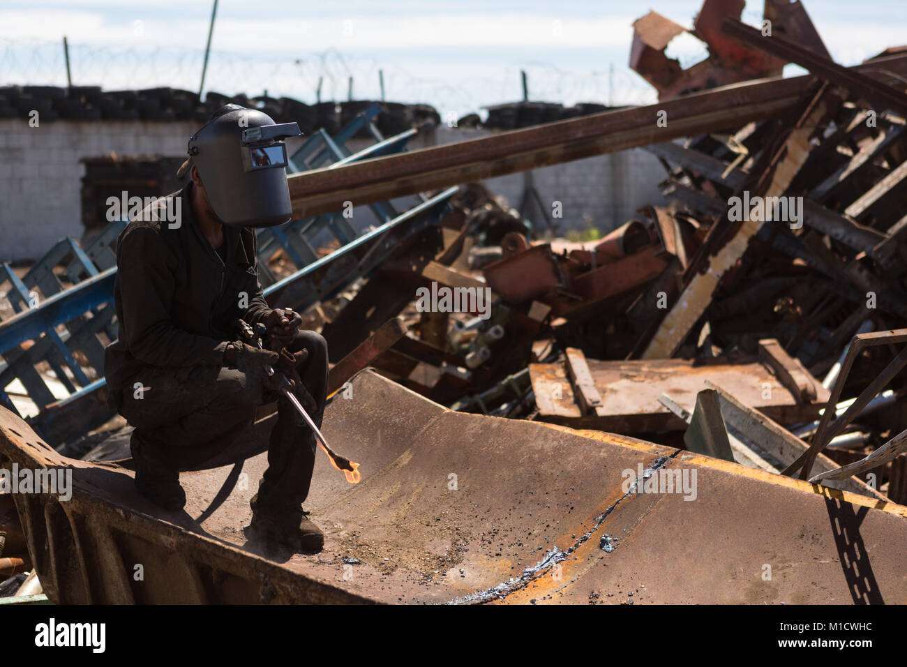 Worker cutting the metal in the scrapyard Stock Photo - Alamy