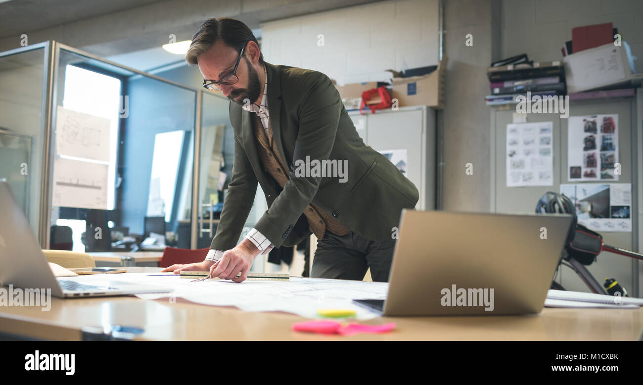 Business executive working on blueprint Stock Photo - Alamy