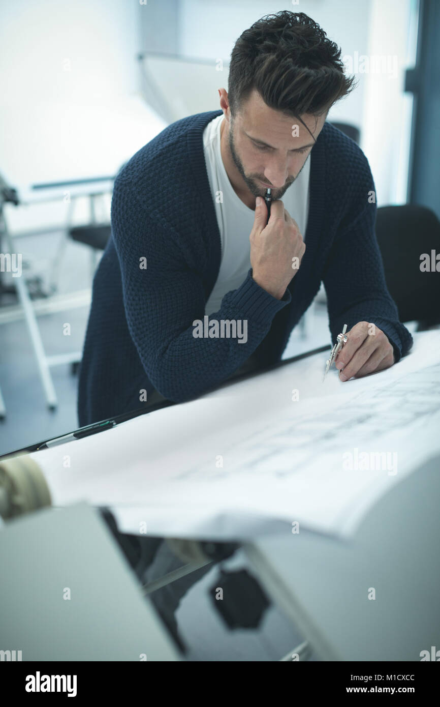 Executive working on blueprint Stock Photo - Alamy