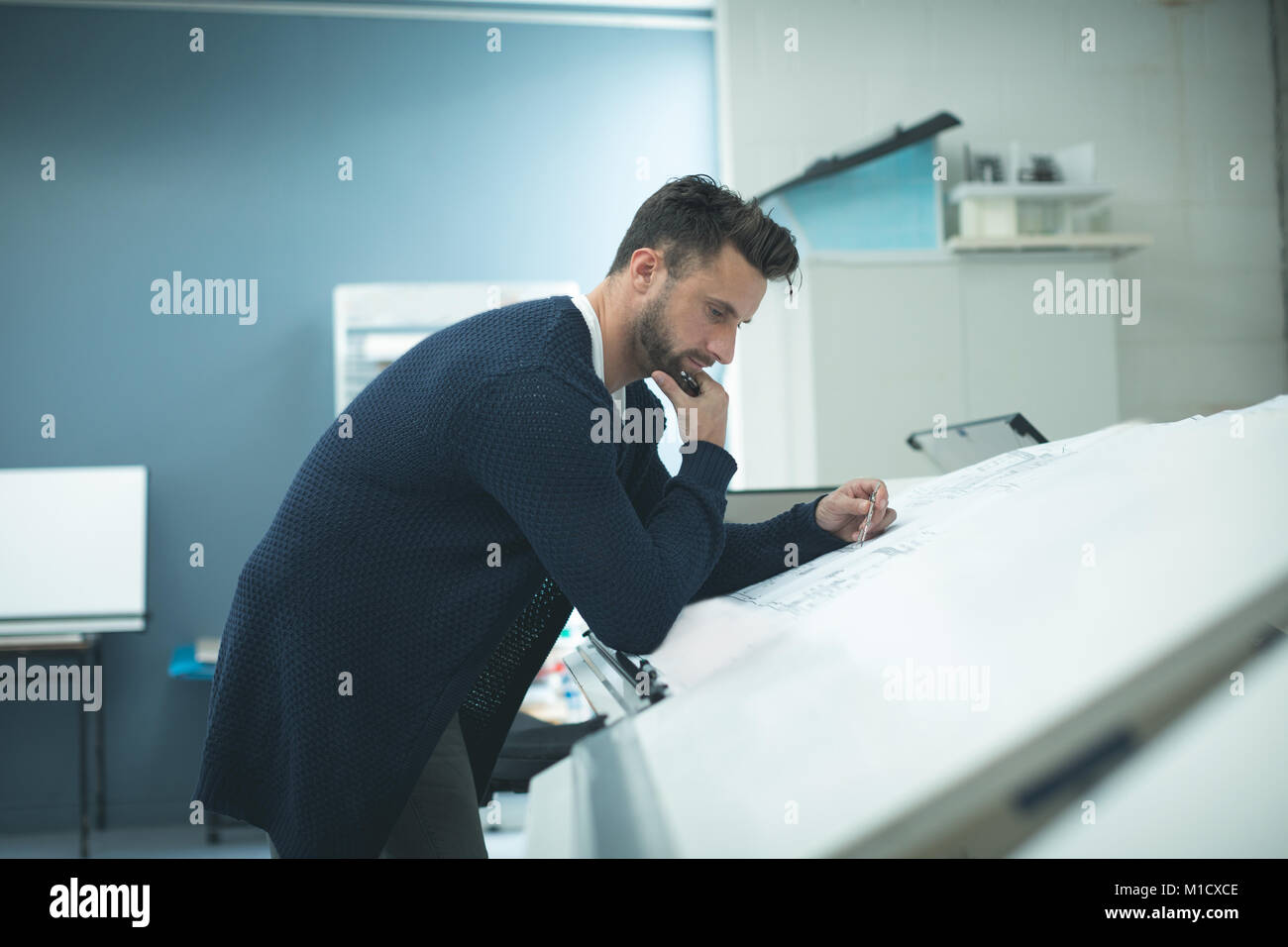 Executive working on blueprint Stock Photo - Alamy