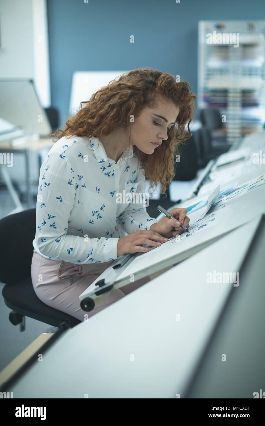 Female executive working over drafting table Stock Photo - Alamy